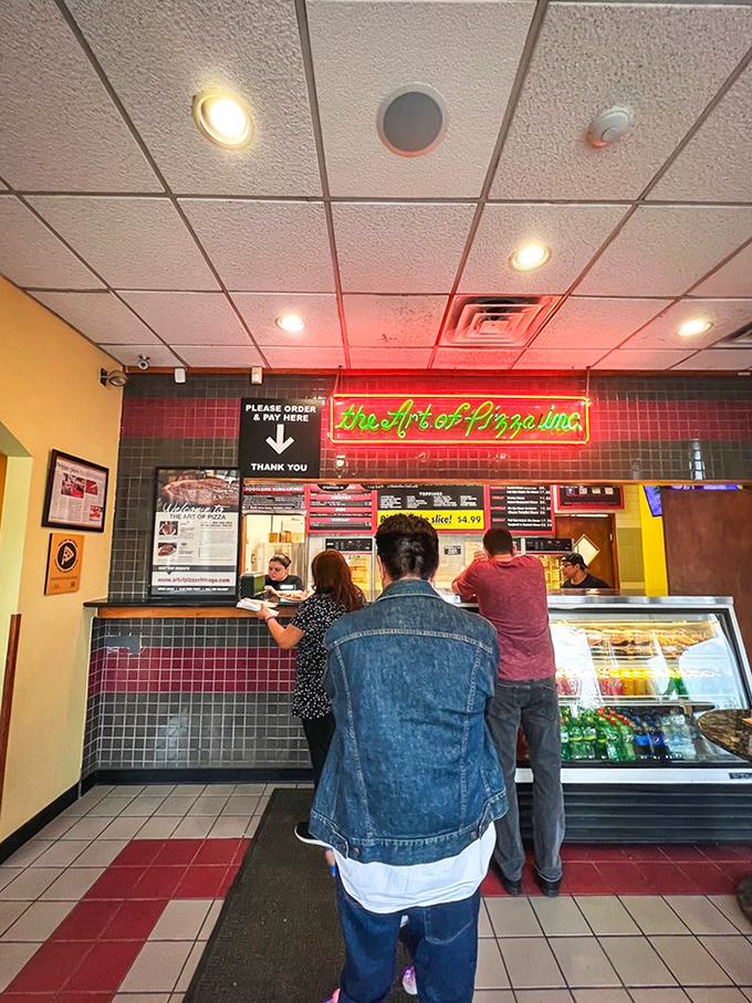The ordering counter &ndash; where pizza dreams begin their journey from dough to delicious reality under that iconic neon sign.