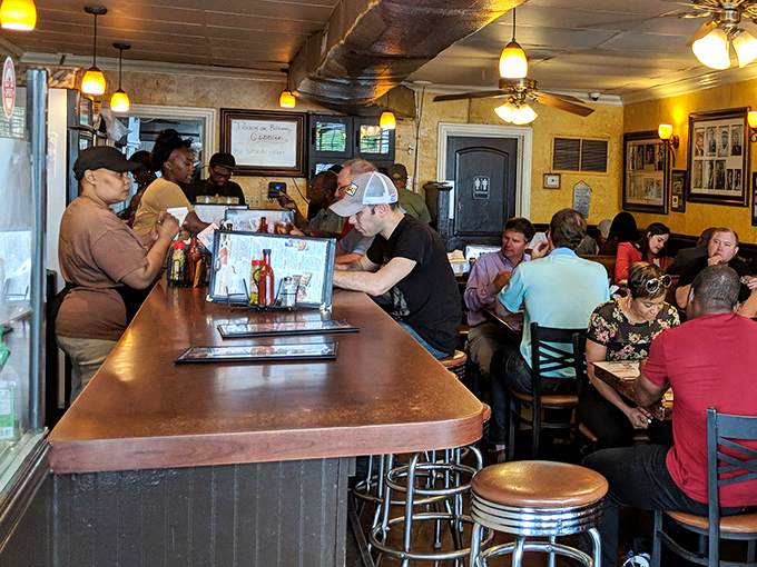 The counter where regulars perch and newcomers become family. This wooden surface has heard more Atlanta stories than any history book.