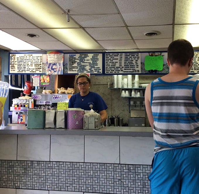 At this counter, dreams come true one scoop at a time. The menu board above holds the secrets to frozen happiness.