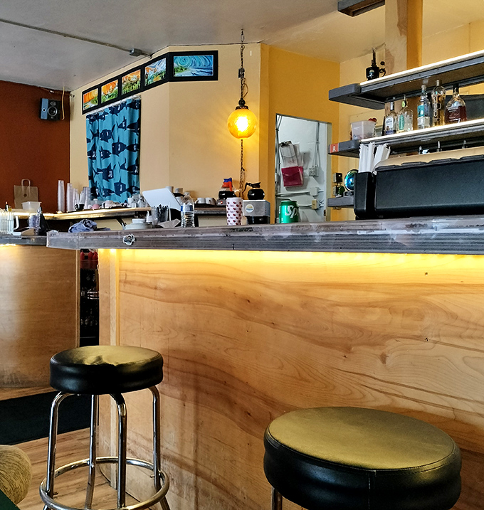 The wooden bar offers prime seating for solo diners or those who enjoy watching the breakfast choreography of a busy kitchen.