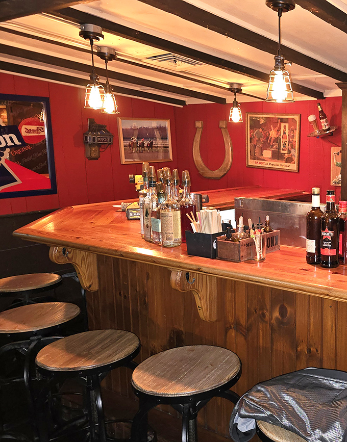 The counter seating area combines warm wood, red walls, and equestrian touches – like sitting in a cozy corner of Kentucky Derby history.