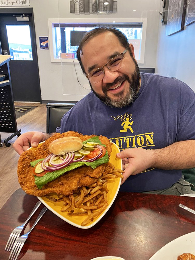The joy on this diner's face says everything – he's not just holding a sandwich, he's cradling the eighth wonder of the culinary world.