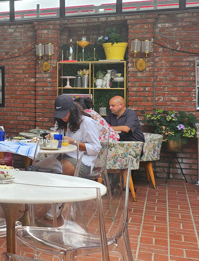 The outdoor patio offers a brick-lined retreat from Venice's bustle. Floral-patterned chairs and thoughtful decor create an urban garden oasis.