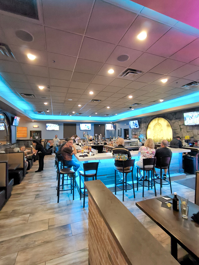 The bar area glows with blue accent lighting, offering a modern gathering spot for pre-dinner drinks and conversation.