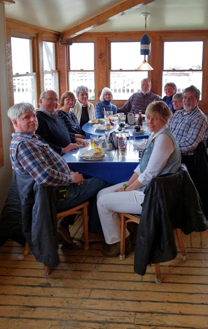 A gathering of happy diners by those panoramic windows proves that good seafood creates better conversations and lasting memories.