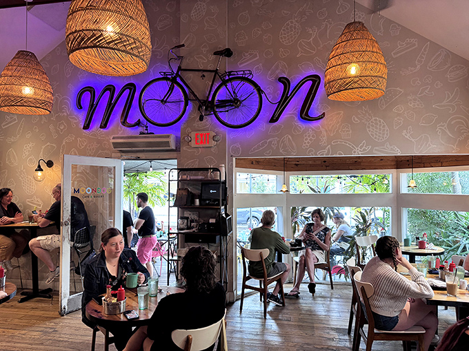 A neon bicycle illuminates the "MOON" in Moondog, while basket pendant lights cast a warm glow over diners enjoying their Key West morning ritual.