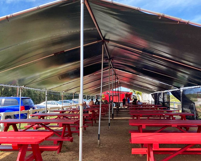 The covered dining area with its red tables creates a communal experience&mdash;strangers united by the universal language of "mmm."