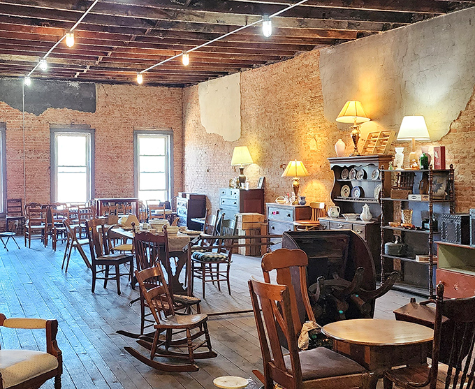 Mismatched chairs and tables arranged like a rustic dining hall where every piece has earned its place through sheer survival.