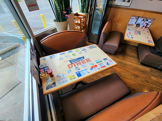 A booth by the window &ndash; prime real estate in the diner kingdom. That laminated placemat has seen more breakfasts than most people have had hot dinners.