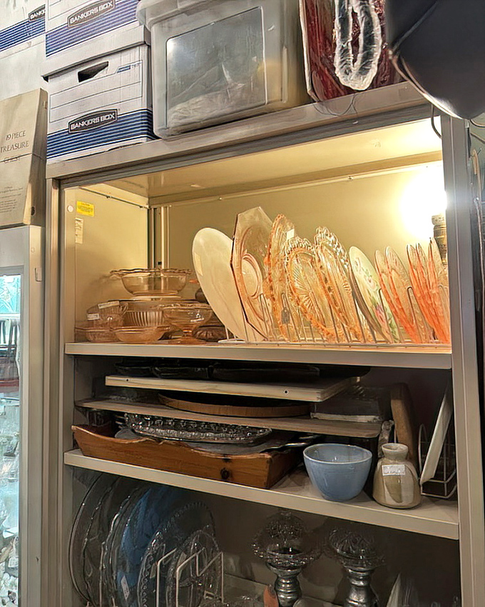 Depression glass and vintage serveware stacked with the precision of a culinary archaeologist, each piece preserving the ghosts of dinner parties past.