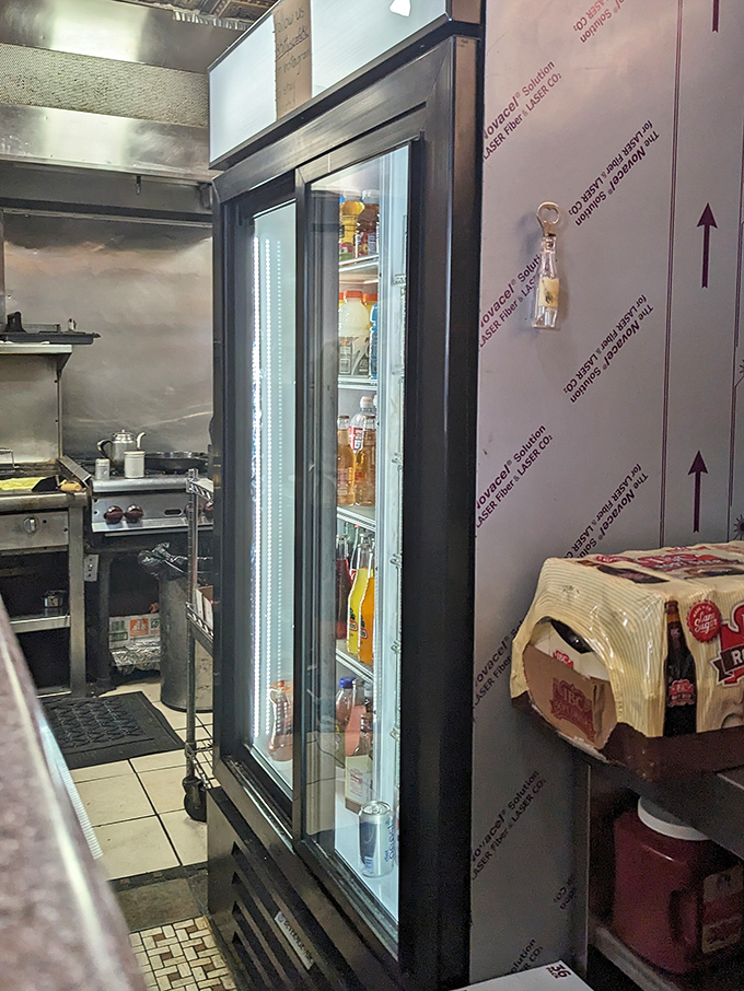 Behind the scenes where refreshment meets preparation. This cooler of drinks stands ready to extinguish the fire of Kitty's legendary spiced breading. 
