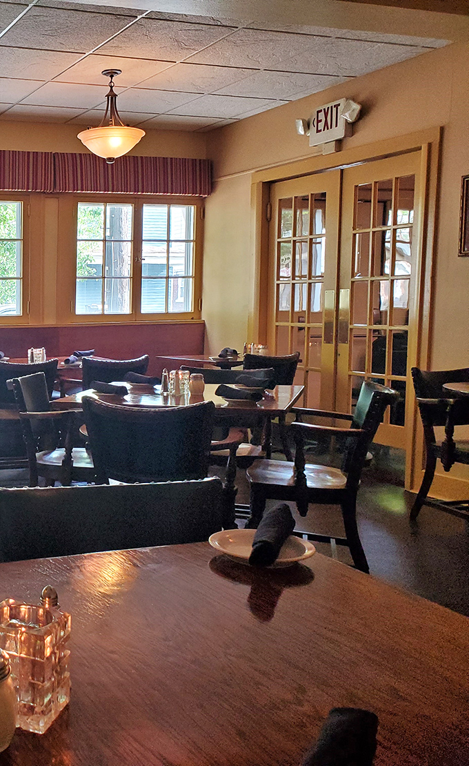 Sunlight streams through French windows into a dining room that feels both elegant and comfortably familiar.
