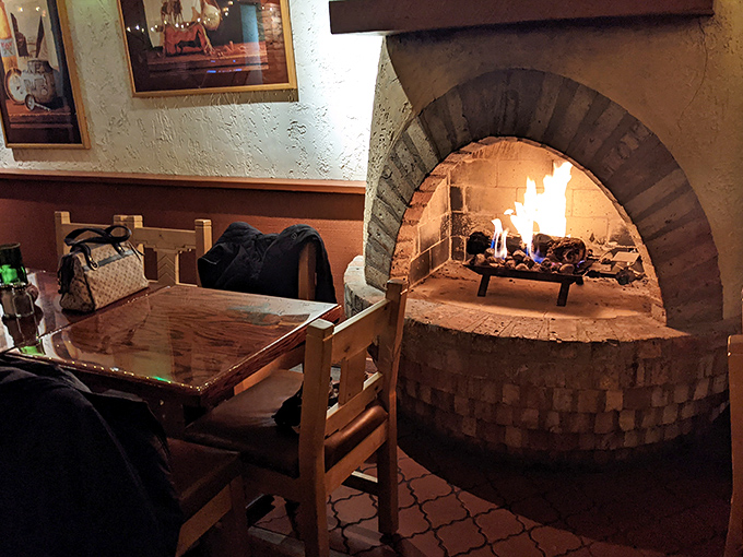 The flickering fireplace doesn't just provide warmth; it creates the primal connection between fire, food, and fellowship that defines great dining.