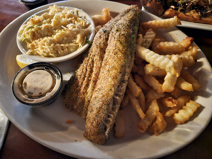 This fish isn't just fried, it's transformed – golden, crispy exterior giving way to flaky perfection, with fries and slaw playing perfect backup.