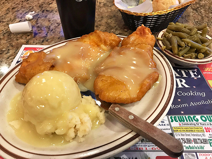 Comfort food nirvana: tender chicken smothered in gravy alongside creamy mashed potatoes and green beans&mdash;a plate Norman Rockwell would paint.