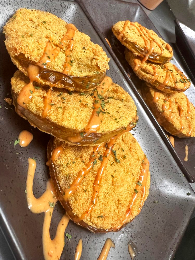 Fried green tomatoes drizzled with remoulade&mdash;Southern ingenuity on a plate that transforms the humble tomato into something magical.