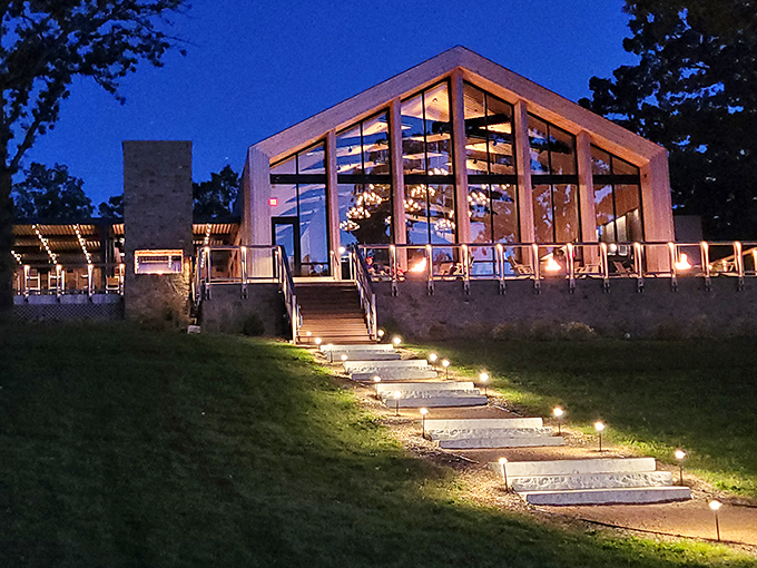 As twilight falls, the illuminated glass pavilion glows like a beacon of culinary promise against the Wisconsin night sky.