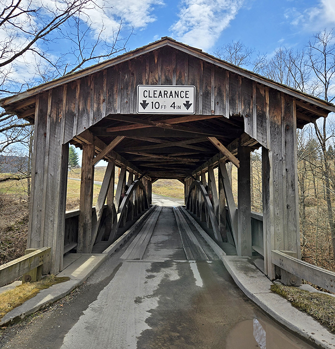Morning light reveals every detail of the bridge's entrance. The clearance sign serves as both practical warning and historical marker.