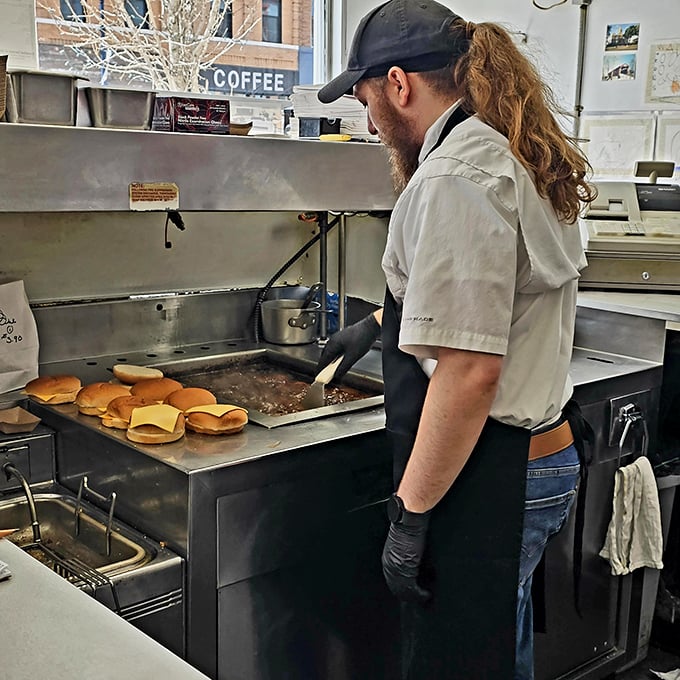 The flat-top grill works overtime creating burger magic, toasting buns to golden perfection while cheese melts into pure happiness.