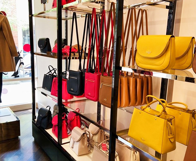 Handbag displays arranged like colorful candy, equally tempting and potentially budget-destroying for shoppers.