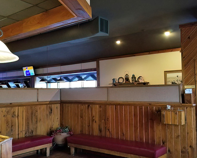 Wooden walls, burgundy benches, and warm lighting create that distinctly American steakhouse vibe where comfort meets anticipation.