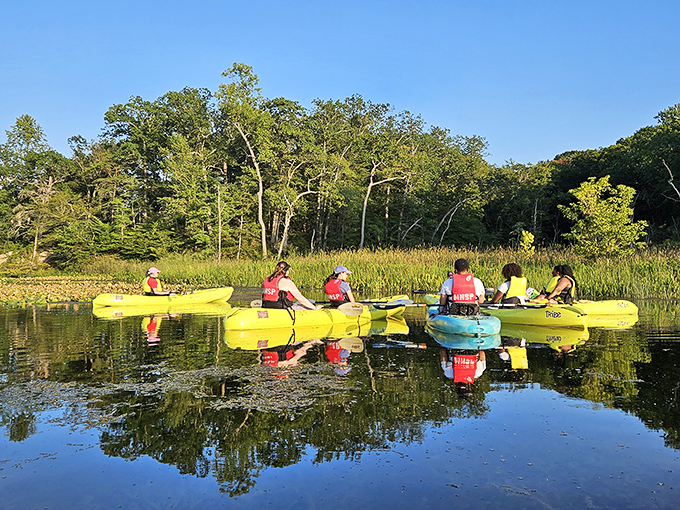 Kayakers glide through reflective waters, creating mirror images so perfect you'd swear Mother Nature was showing off her Photoshop skills.