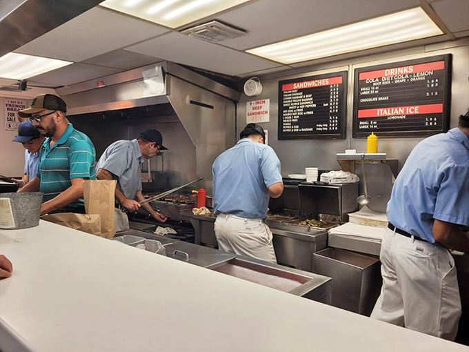 Behind the scenes where the magic happens&mdash;staff focused on the sacred art of beef preparation. No distractions, just dedication.