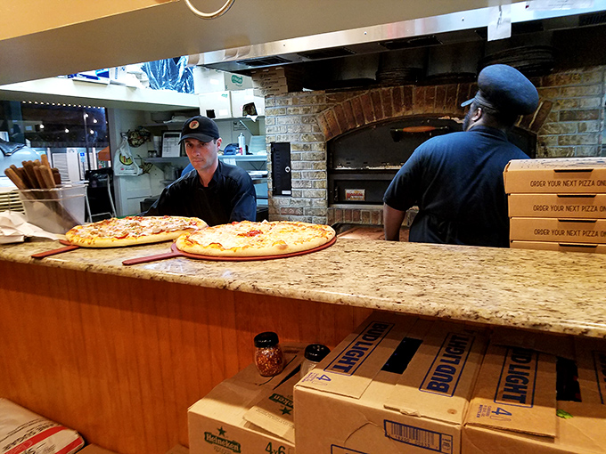 Behind the counter, pizza artisans work their magic at the brick oven&mdash;the heart of Flippers' operation and source of countless happy food memories.