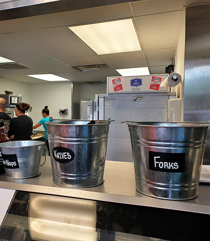 Behind-the-scenes simplicity with metal buckets labeled for silverware, because efficiency matters when you're focused on smoking perfection.
