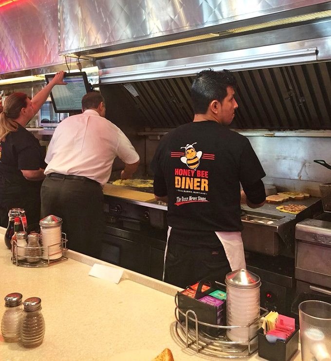 The kitchen crew works their magic behind the counter, where breakfast alchemy turns simple ingredients into gold.