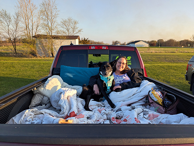 A pickup truck bed transformed into the world's most comfortable theater seat, complete with four-legged movie critic.
