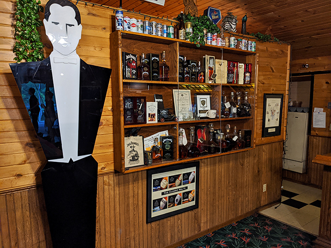 Not just a liquor selection—it's a wall of liquid possibilities guarded by what appears to be the most sophisticated cardboard cutout in Minnesota.