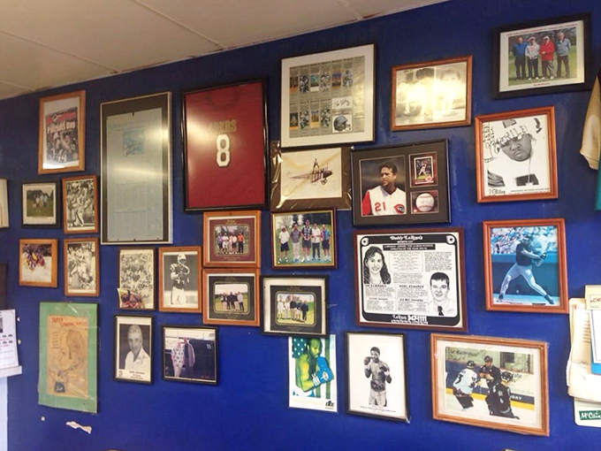 Every frame tells a story &ndash; decades of sports heroes, local memories, and championship moments creating a community scrapbook on blue walls.