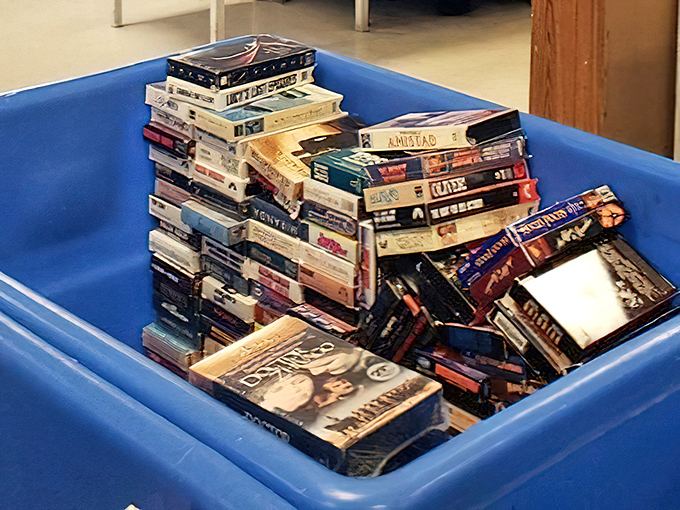 Blue bins overflow with movie memories on tape, representing decades of entertainment history at bargain prices.