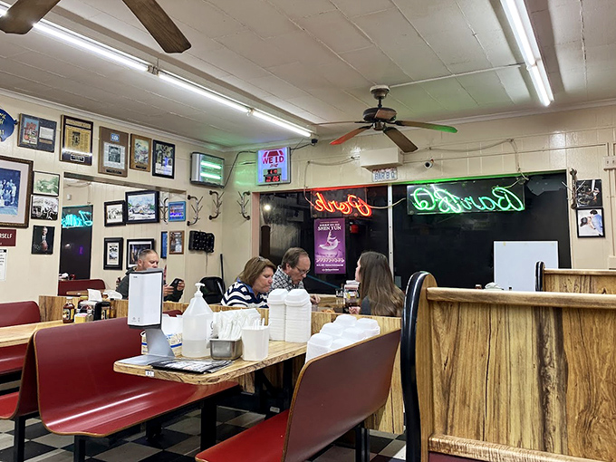 Neon signs glow against wooden booths while diners focus on what matters. In BBQ sanctuaries, conversation stops when the food arrives.