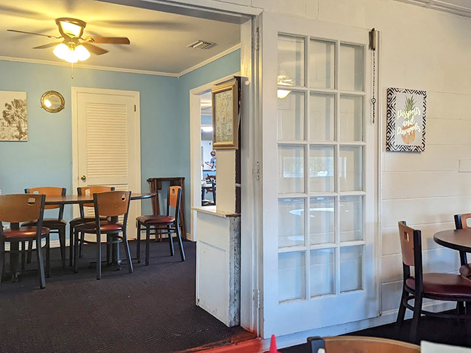 Dining rooms separated by vintage glass doors create intimate spaces where conversations flow as easily as sweet tea.