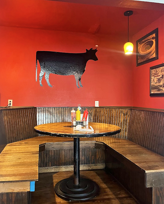 The cow silhouette against the red wall reminds you exactly why you came here: for serious beef business.