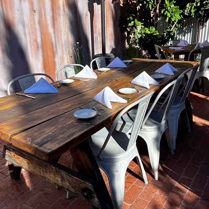 Rustic outdoor seating where California sunshine is an unofficial ingredient. That weathered wood table has hosted more food epiphanies than a cooking show.