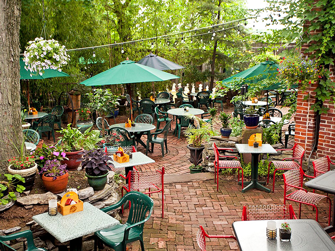 The outdoor patio blooms with colorful flowers and umbrellas, creating a secret garden where beer tastes better and conversations flow easier.