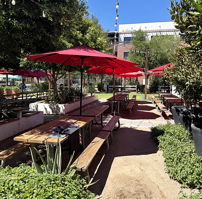 The outdoor patio: where Arizona sunshine meets barbecue bliss under cheerful red umbrellas. Even the cacti look happy to be here.