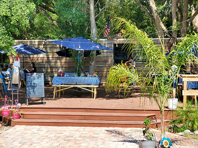 The outdoor seating area offers a taste of Old Florida charm&mdash;blue checkered tablecloths under dappled sunlight filtering through native palms.
