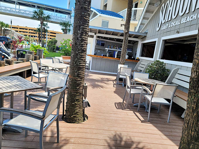 Palm trees growing through the deck aren't decorative choices&mdash;they were here first, and Schooners respectfully built around them. That's beach life.