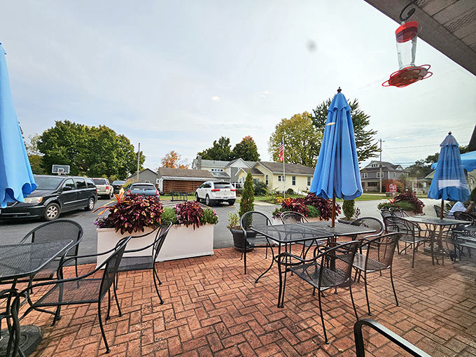 The outdoor seating area transforms ordinary Tuesday lunches into mini-vacations, complete with blue umbrellas and flowering planters.