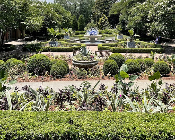 Formal gardens meet playful design in this geometric paradise where boxwoods frame colorful plantings like living picture frames.