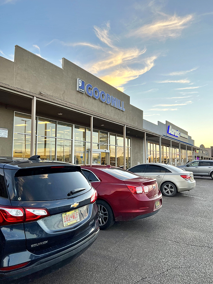 As the sun sets behind the Goodwill sign, shoppers' cars wait patiently, trunks ready to be filled with treasures.