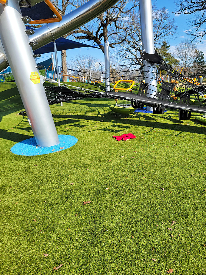 Modern playground equipment reaching skyward like a child's imagination, with safety surfaces below for when gravity inevitably wins.