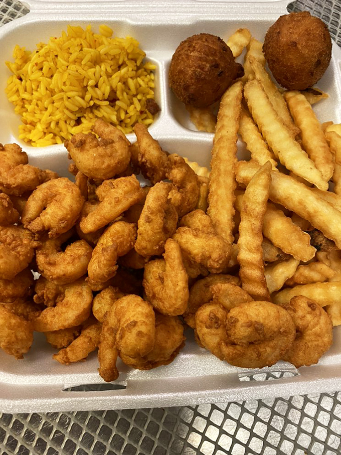 A takeout feast featuring golden shrimp, crinkle-cut fries, and hush puppies &ndash; proof that sometimes the best dining room is wherever you happen to be.