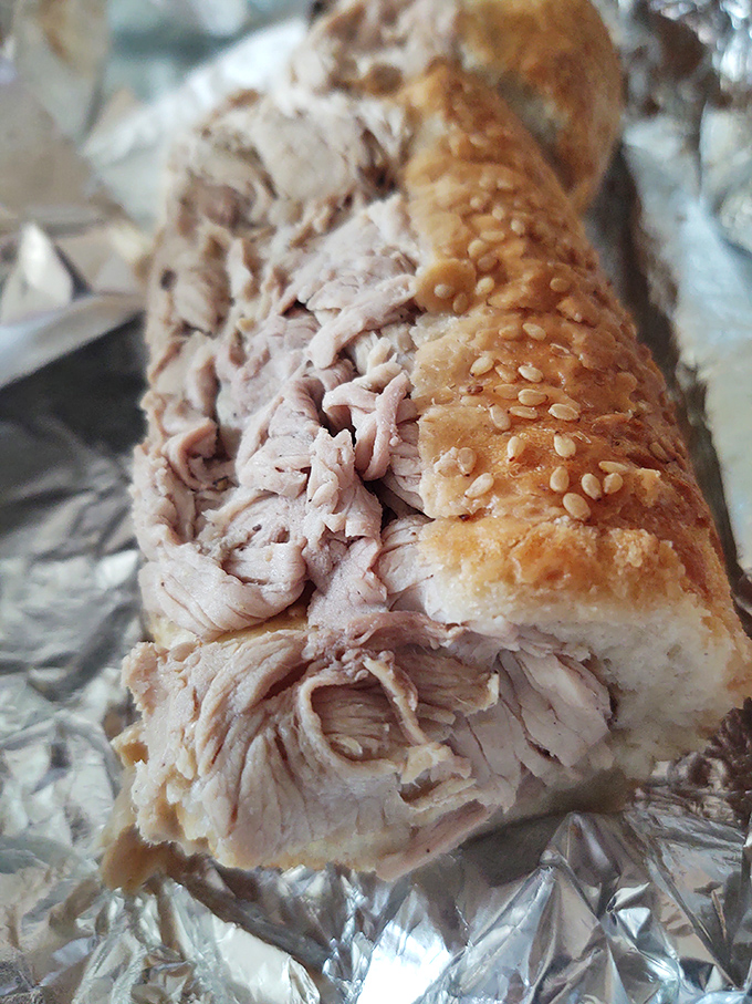 This porchetta sandwich isn't just lunch—it's a religious experience wrapped in aluminum foil instead of stained glass.