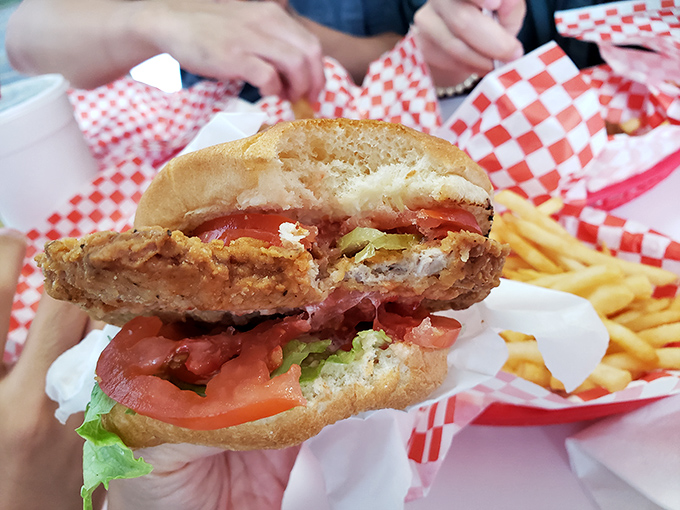 The pork tenderloin sandwich arrives like a crispy-edged celebrity, spilling out of its bun with Midwestern generosity that demands a two-handed approach.