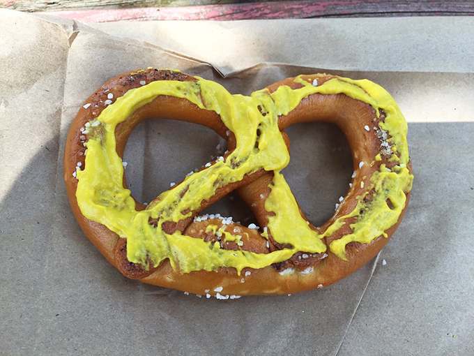 That vibrant yellow mustard stripe across a traditional pretzel isn't just a condiment&mdash;it's a bold fashion statement in the world of handheld snacks.